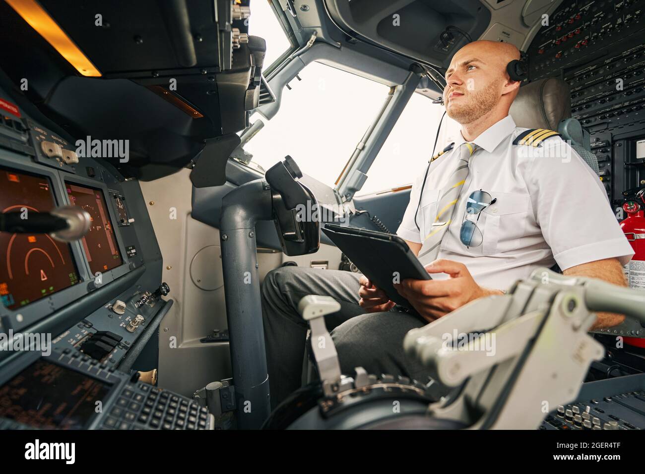 Serious male pilot staring at the aircraft control panel Stock Photo ...