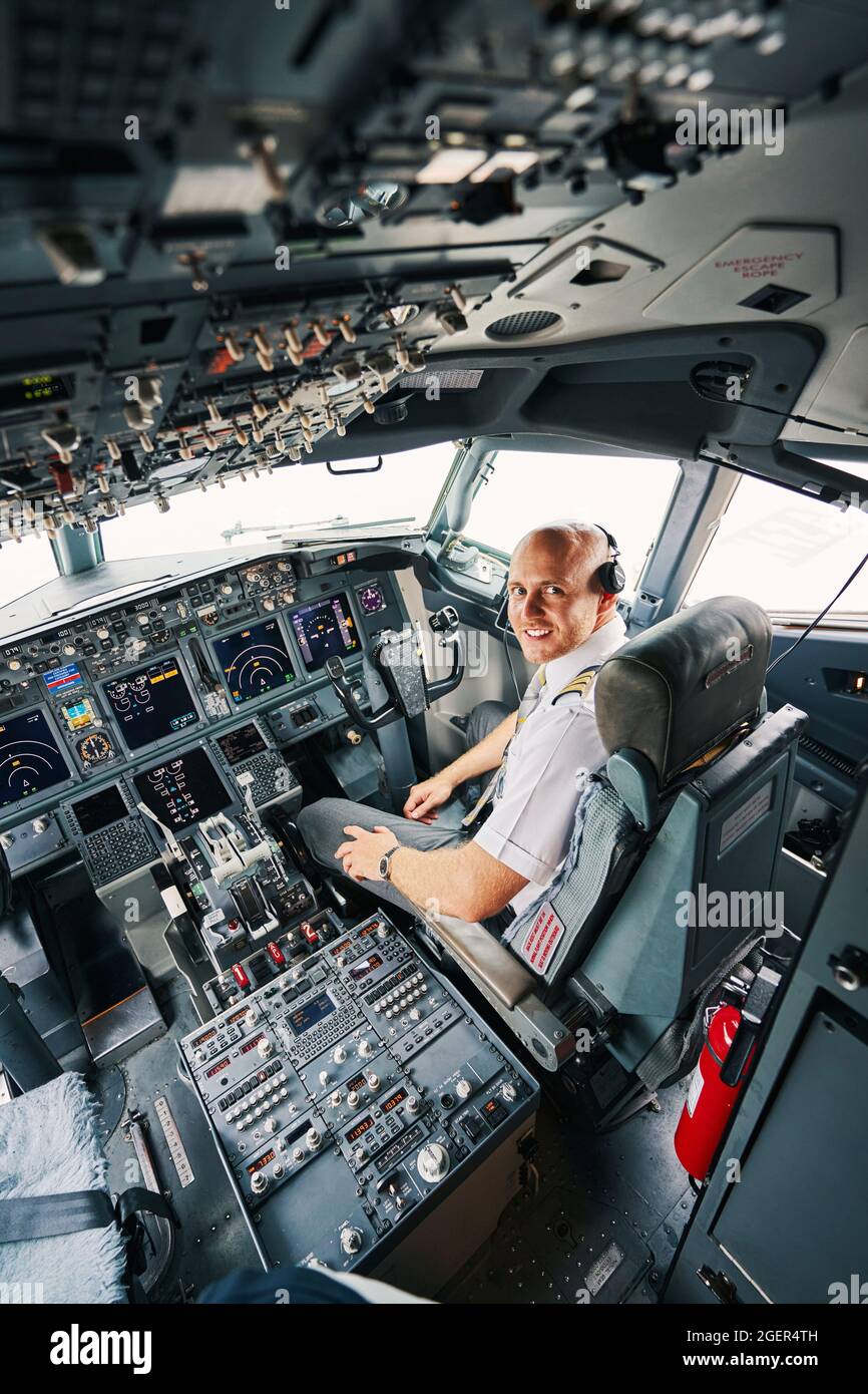 Pleased young pilot sitting in the cockpit before the take-off Stock ...