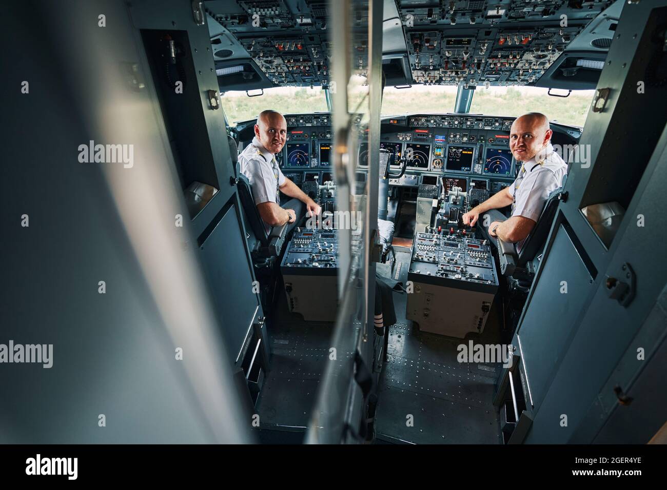 Pleased airline captain in headphones sitting in the flight deck Stock ...