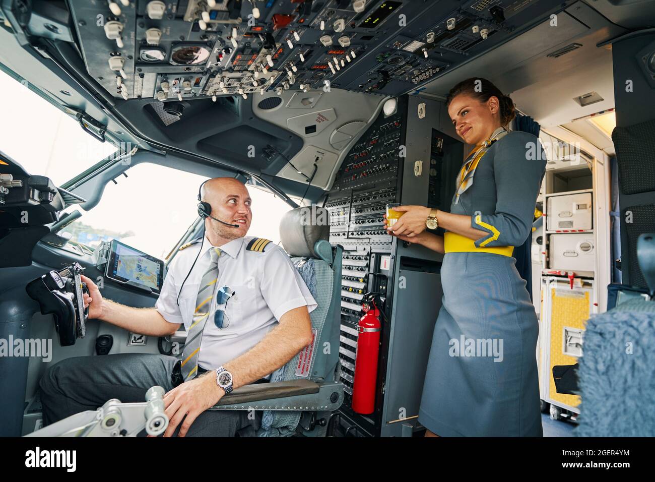 Pleased airline captain being served a drink in the cockpit Stock Photo ...
