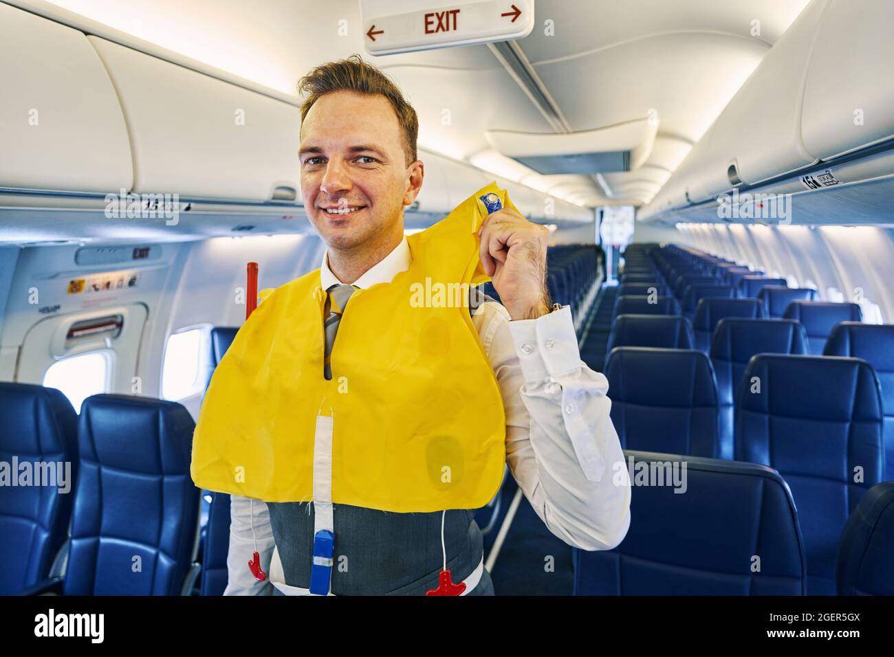Joyous steward wearing a life vest aboard the aircraft Stock Photo - Alamy
