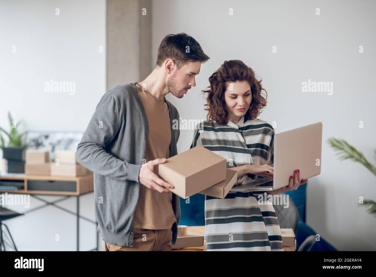 Two young employees working together at an Internet shop Stock Photo ...