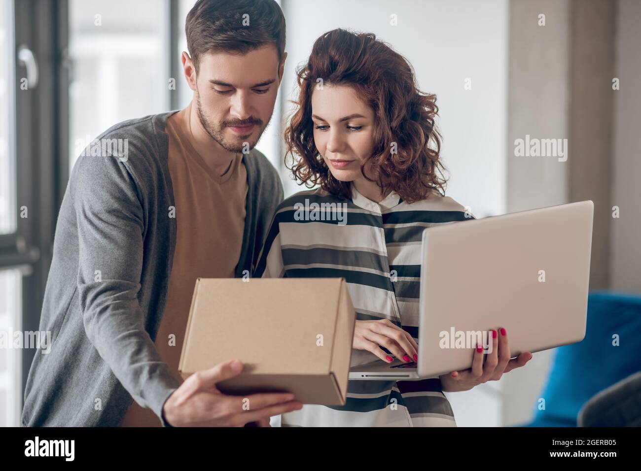 Two focused Internet store coworkers preparing merchandise for shipping ...