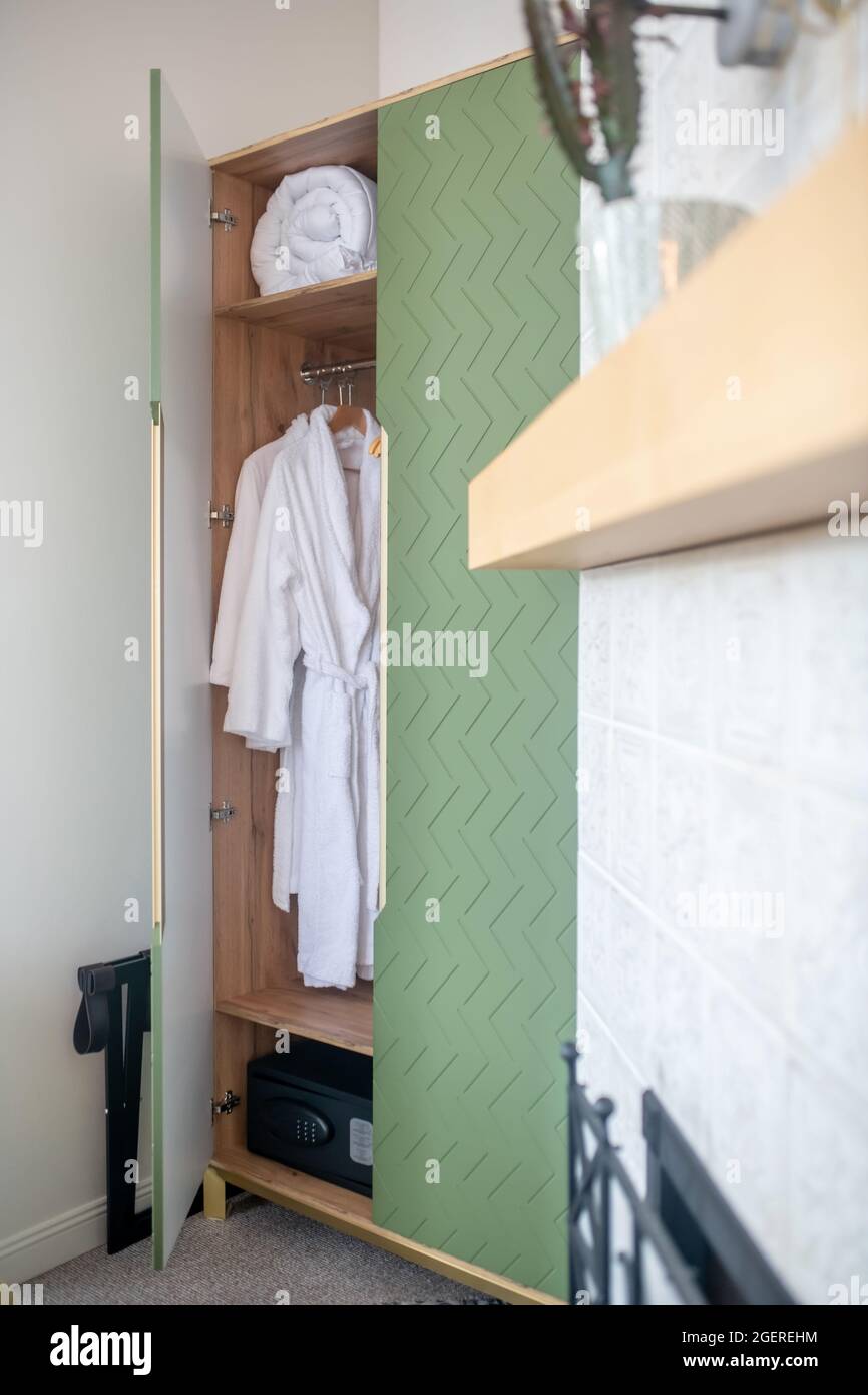 Open wardrobe with bathrobe in room Stock Photo - Alamy