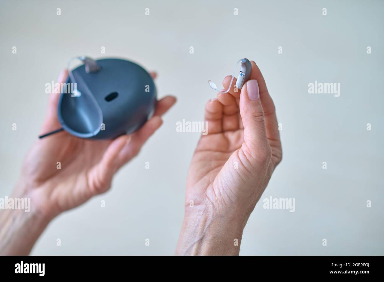 Hand pulling out listening apparatus from case Stock Photo - Alamy