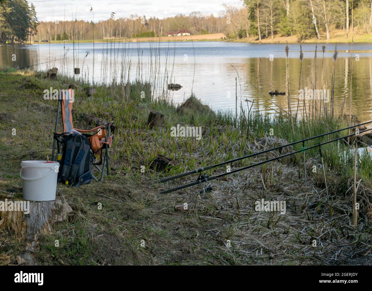 spring landscape with a lake, fishing on the lake shore, calm water ...