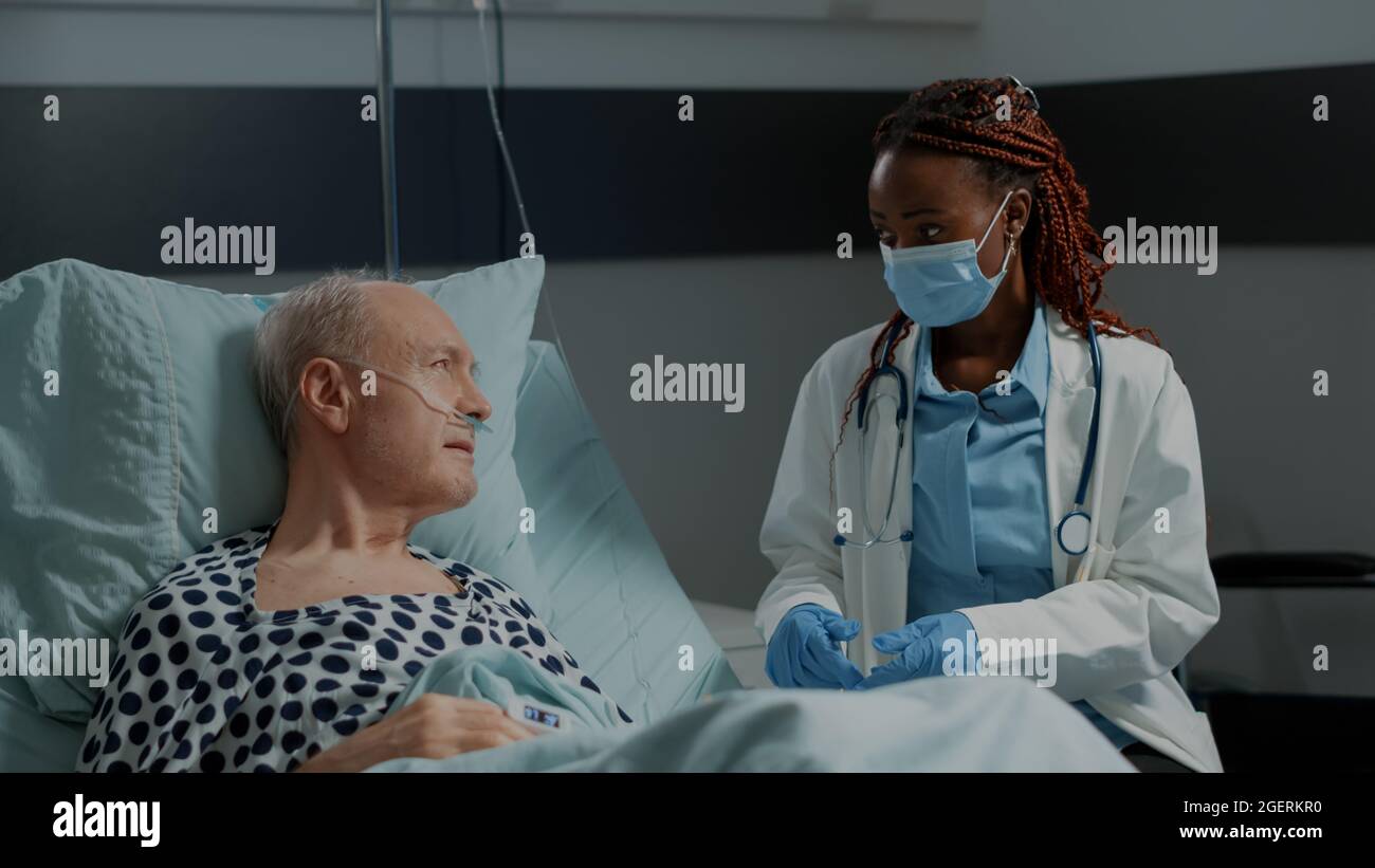 Recovering patient in hospital ward getting consultation from african ...