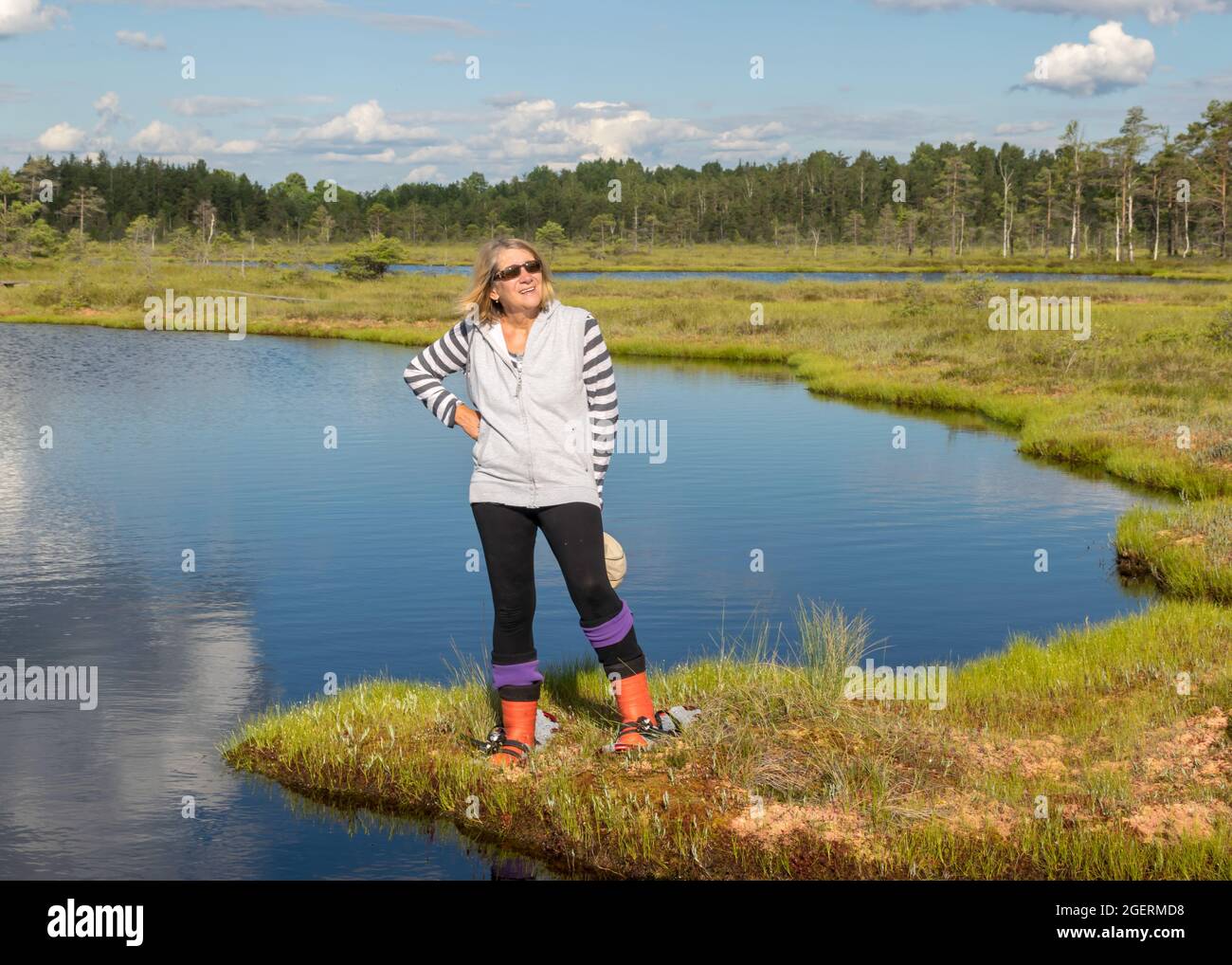 beautiful swamp landscape with blue sky and water, woman enjoys swamp ...