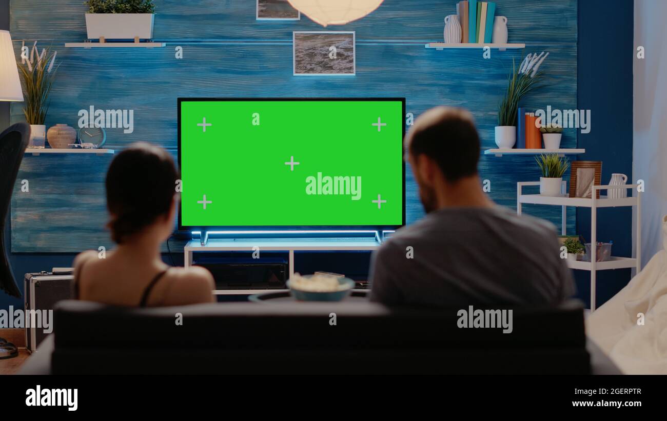 Caucasian individuals using television for green screen sitting on ...