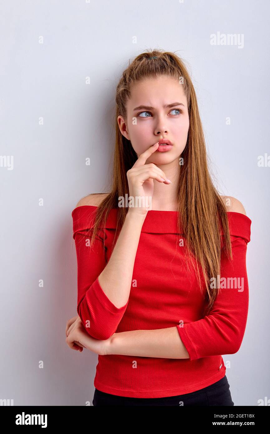 Unsure perplexed young girl with distrustful face isolated on white ...
