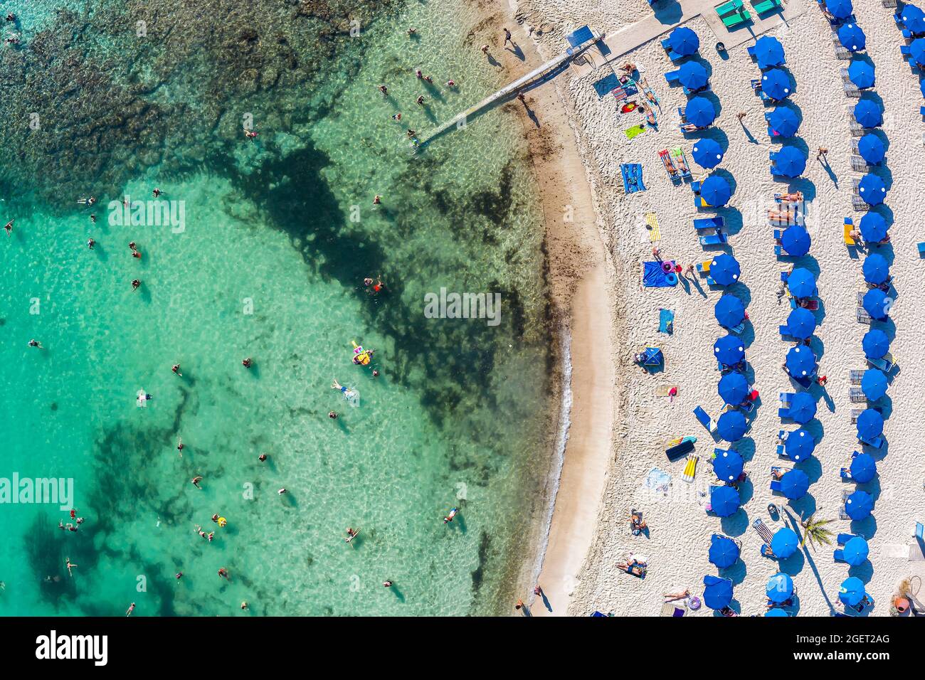 Overhead view of Sandy Bay beach in Cyprus with swimmers and sunbathers ...