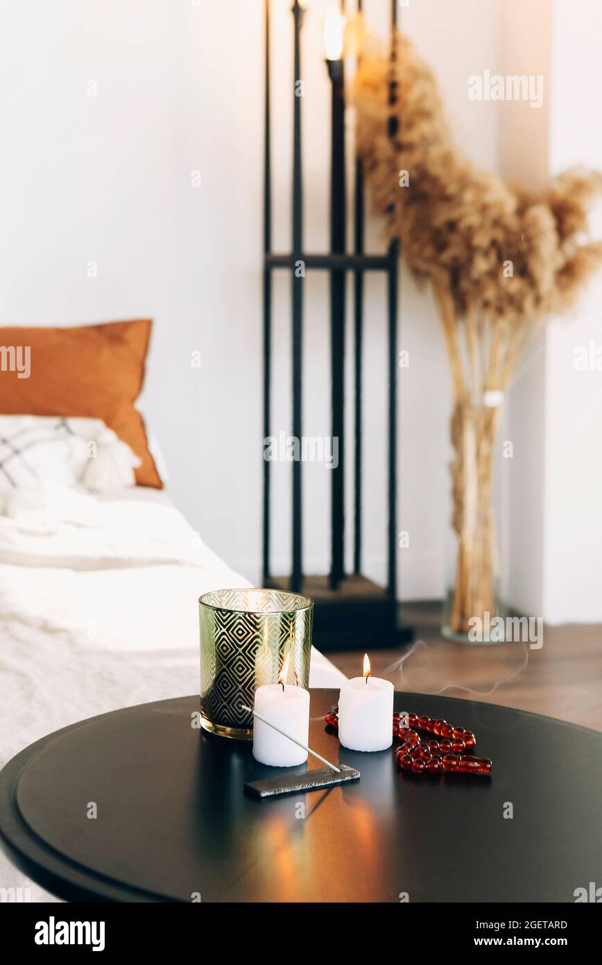Cropped photo of cozy bedroom interior. Round table with burning ...