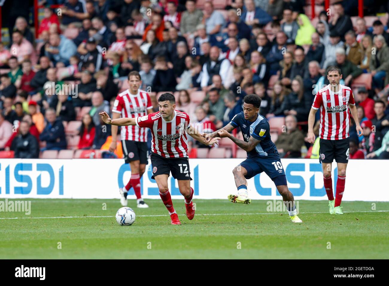 John Egan #12 of Sheffield United and Josh Koroma #10 of Huddersfield ...