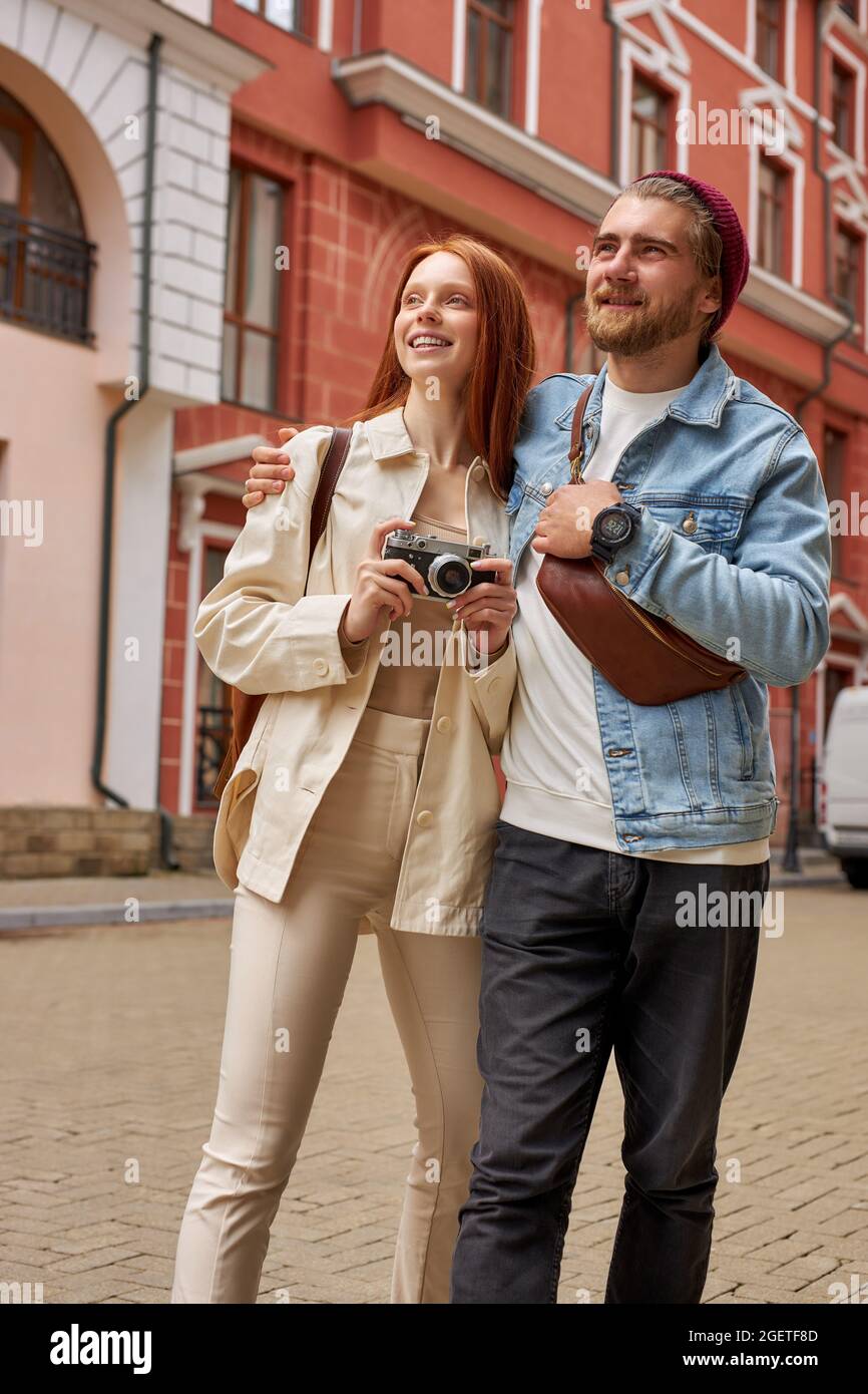 Caucasian tourists man and woman taking photo of architecture on retro ...