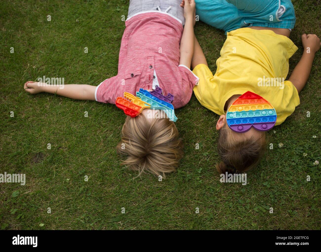 faceless children playing with colorful toys Pop It. Boys on vacation ...