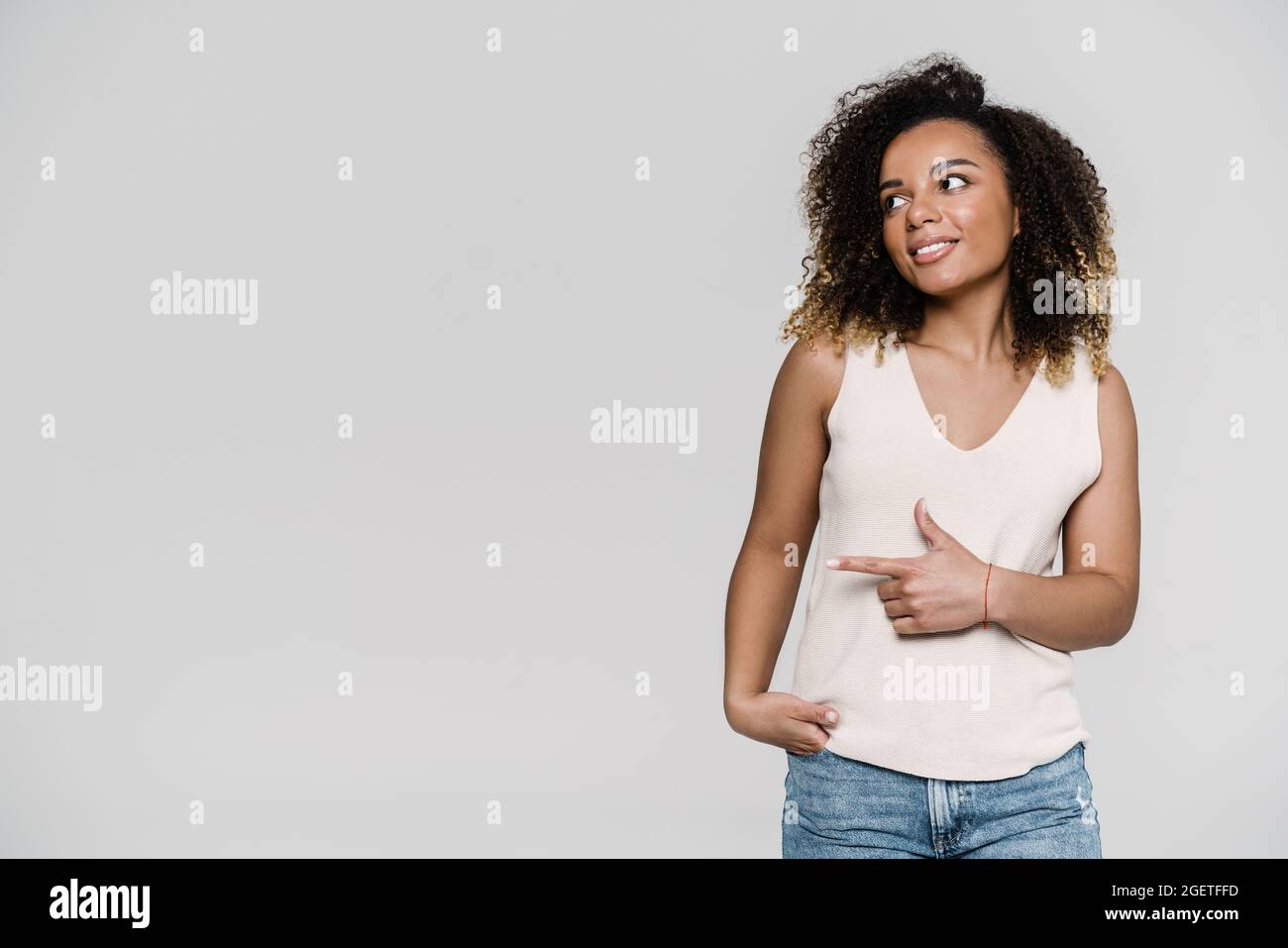 A woman standing to the right of the camera looking and pointing with ...