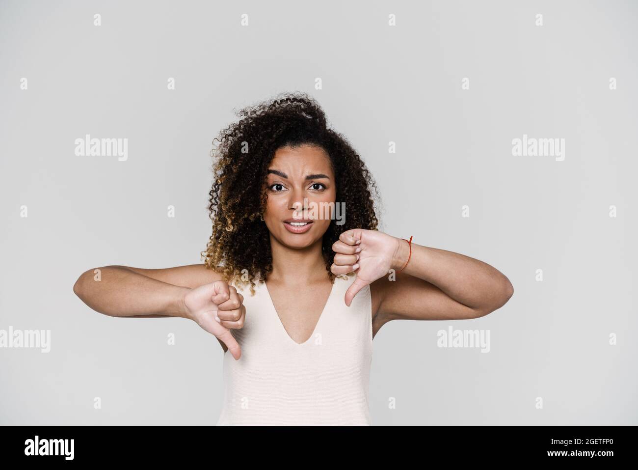 The upset woman showing two thumbs-down gesture while standing in the ...
