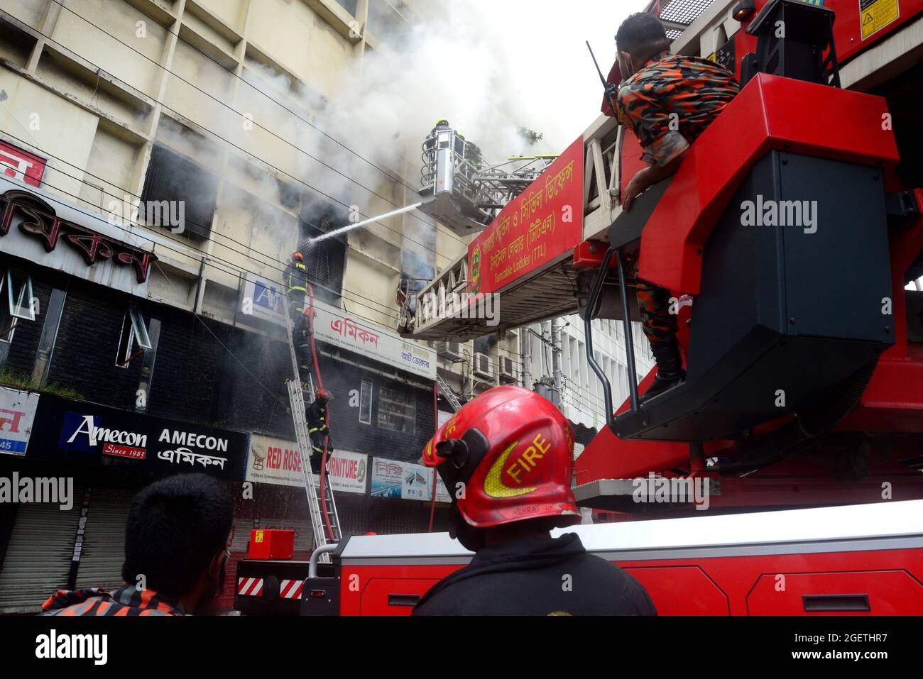 Firefighters try to extinguish a fire at a building at Bonani area in ...