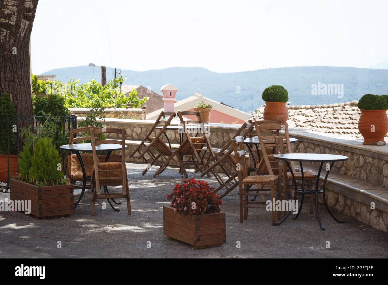 cafe on the square of a small town. tables and chairs with Mountain ...