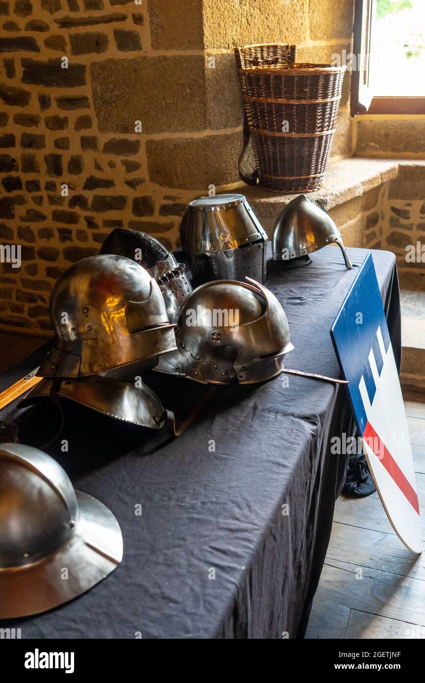 Vertical shot of medieval knight armor helmets on a table in the castle ...