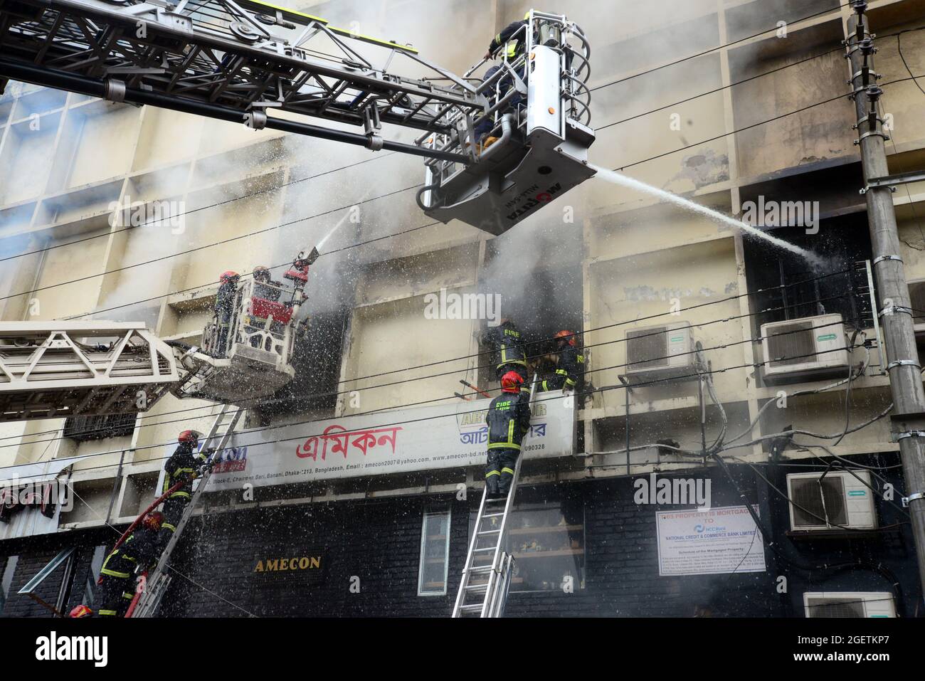 Firefighters try to extinguish a fire at a building at Bonani area in ...
