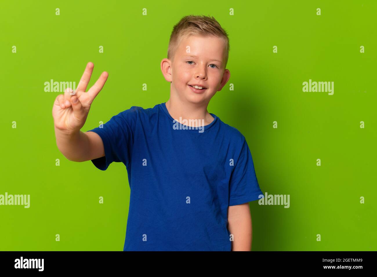 portrait of little boy showing victory hand sign Stock Photo - Alamy