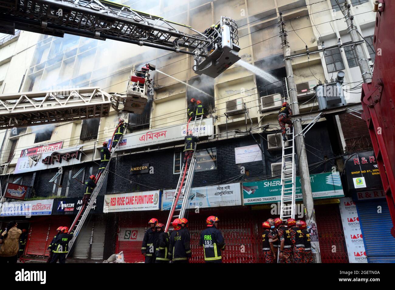 Firefighters try to extinguish a fire at a building at Bonani area in ...