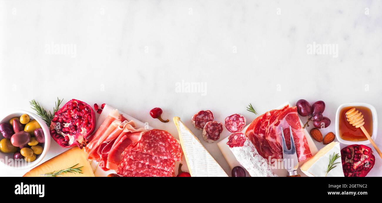 Variety of cheese and meat appetizers. Top view bottom border on a ...