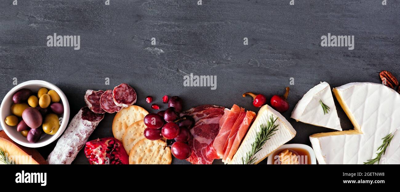 Assortment of cheese and meat appetizers. Top view bottom border on a ...