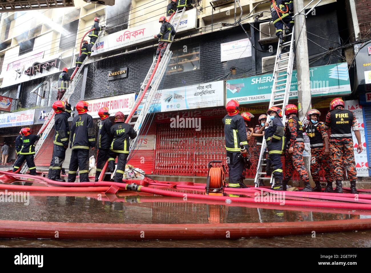Firefighters try to extinguish a fire at a building at Bonani area in ...