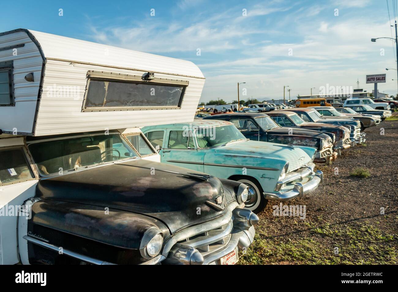 vintage 1955 Cadillac American camper van and cars in a desert junk ...
