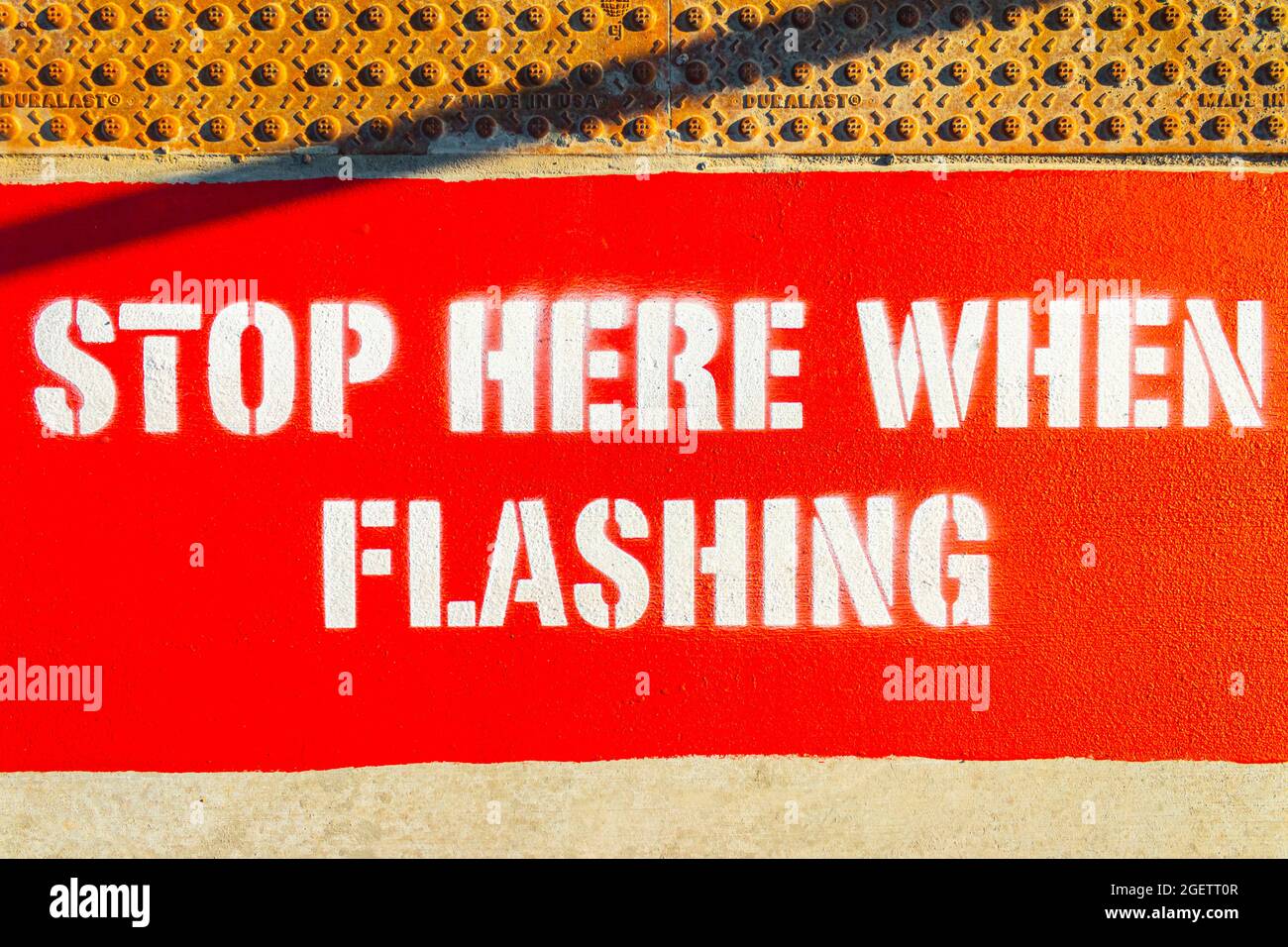 Stop here when flashing stencilled sign on railway platform Stock Photo ...