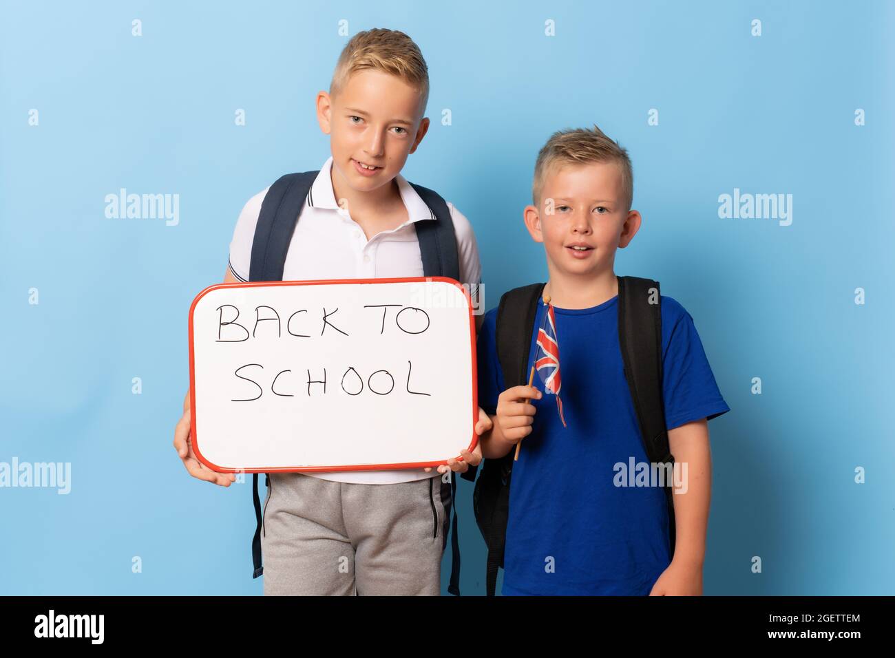Two boys with thumbs up ready to school over green background Stock ...