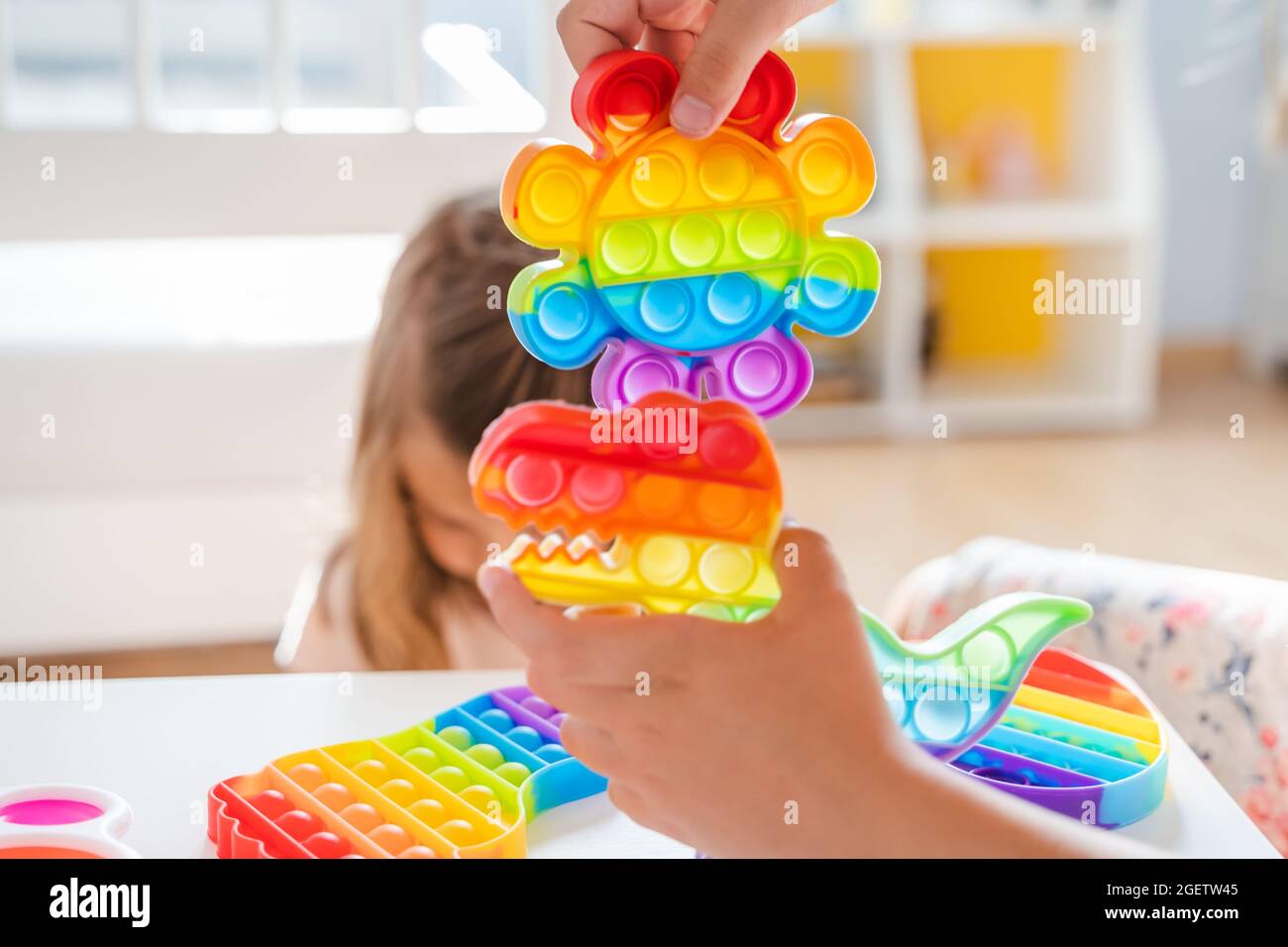 Little girls,kids,sisters play with colorful pop it children room ...