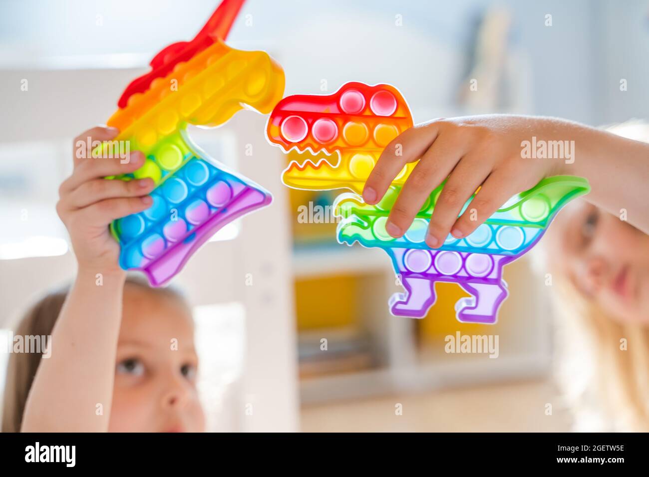 Little girls,kids,sisters play with colorful pop it children room ...