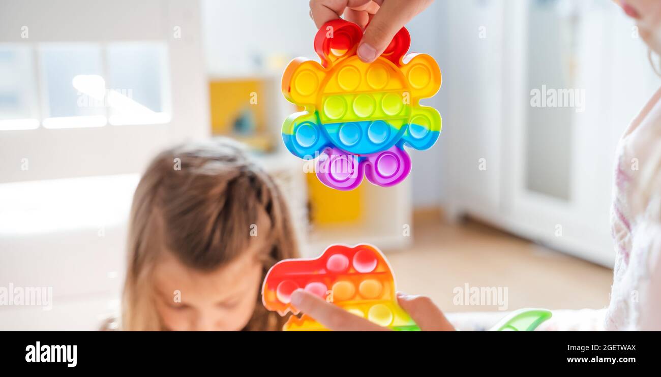 Little girls,kids,sisters play with colorful pop it children room ...