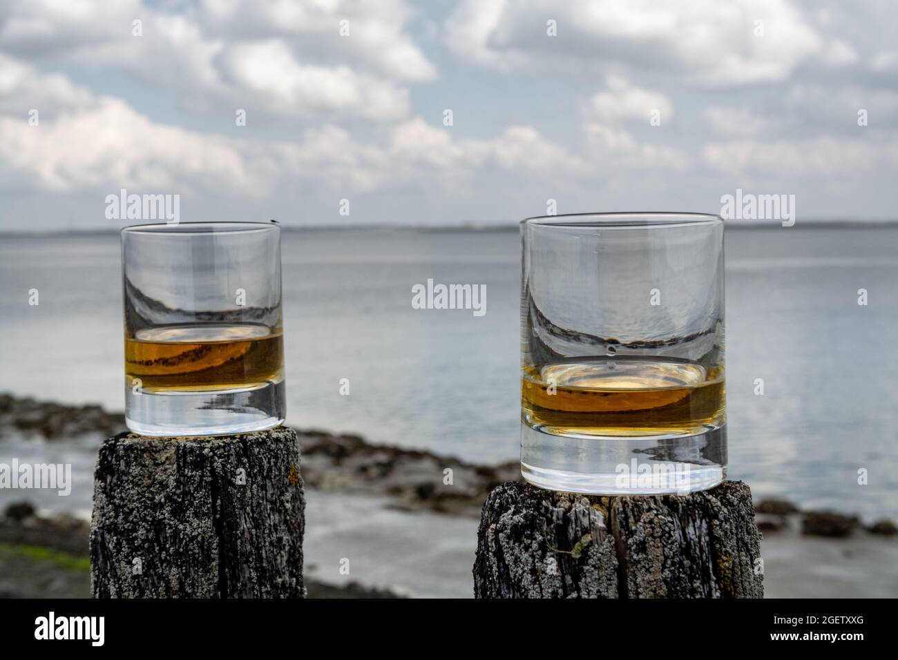 Tasting of dram single malt scotch whisky on seashore in Scotland, old ...
