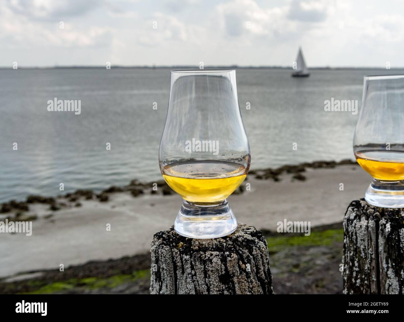Tasting of dram single malt scotch whisky on seashore in Scotland, old ...