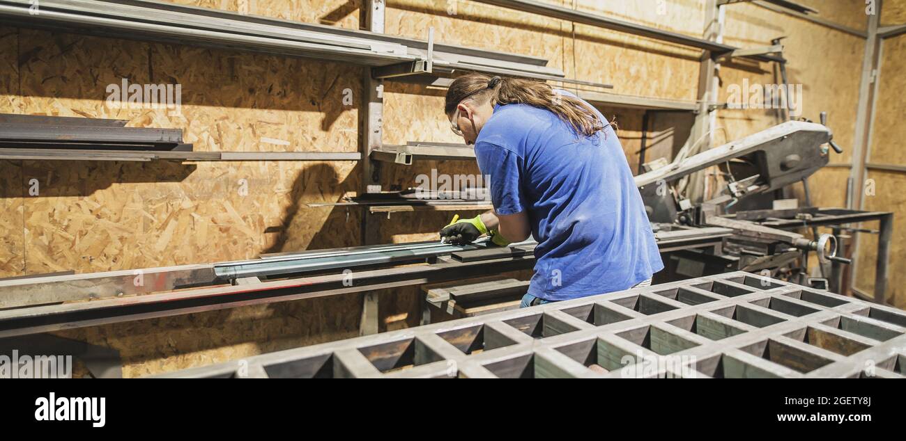 Craftsman worker working on steel structure in factory. Metal work ...