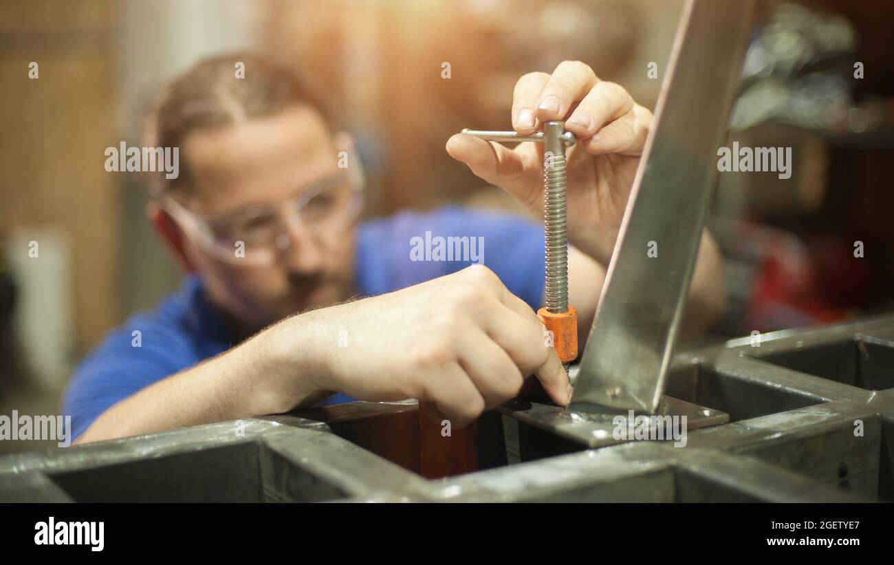 Craftsman worker working on steel structure in factory. Metal work ...