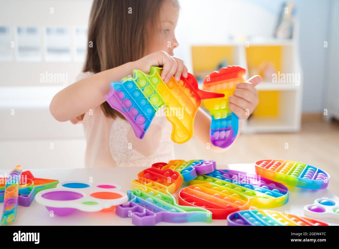 Little girl,kid,child plays with colorful pop it children's room ...