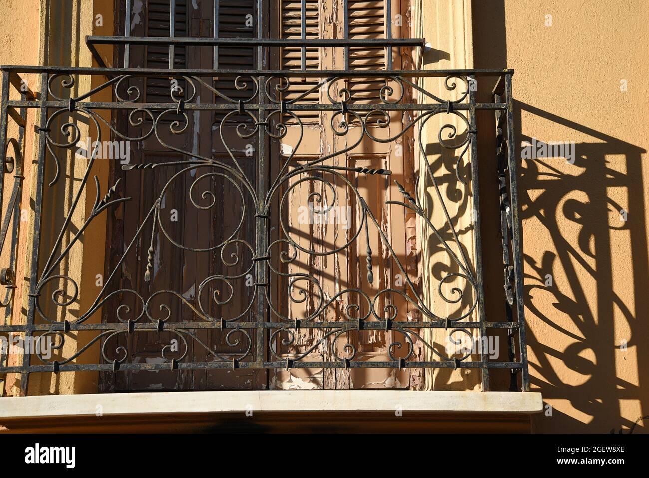 Old Neoclassical house facade with an ochre stucco wall and a balcony ...