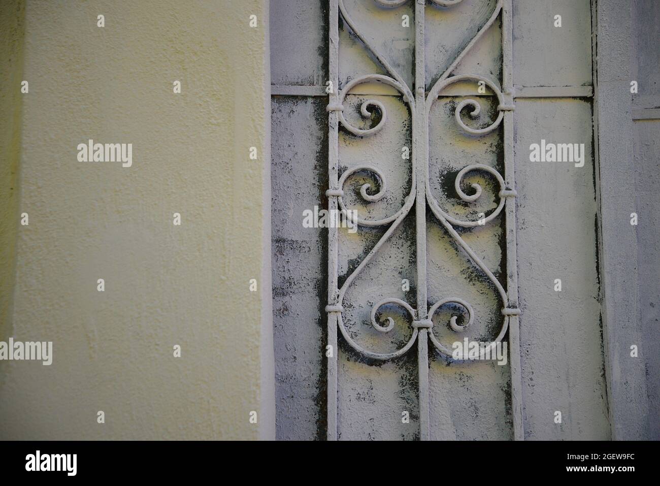 Handcrafted detail of an old wrought iron door on a stucco wall in ...