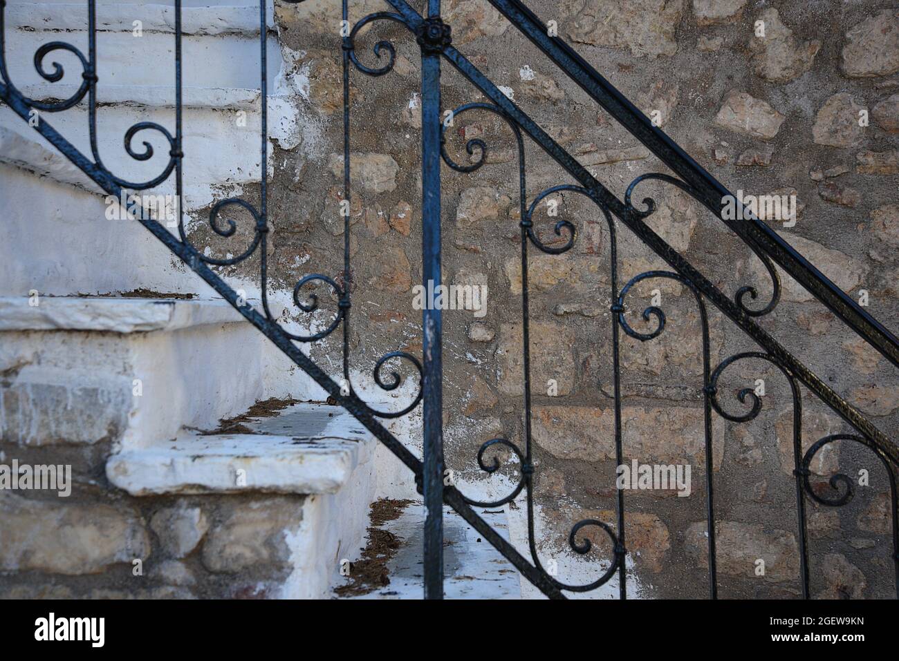 Traditional handcrafted wrought iron stairway railing against an aged ...