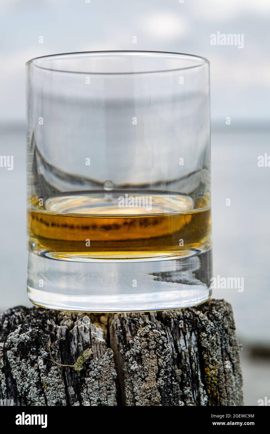 Tasting of dram single malt scotch whisky on seashore in Scotland, old ...