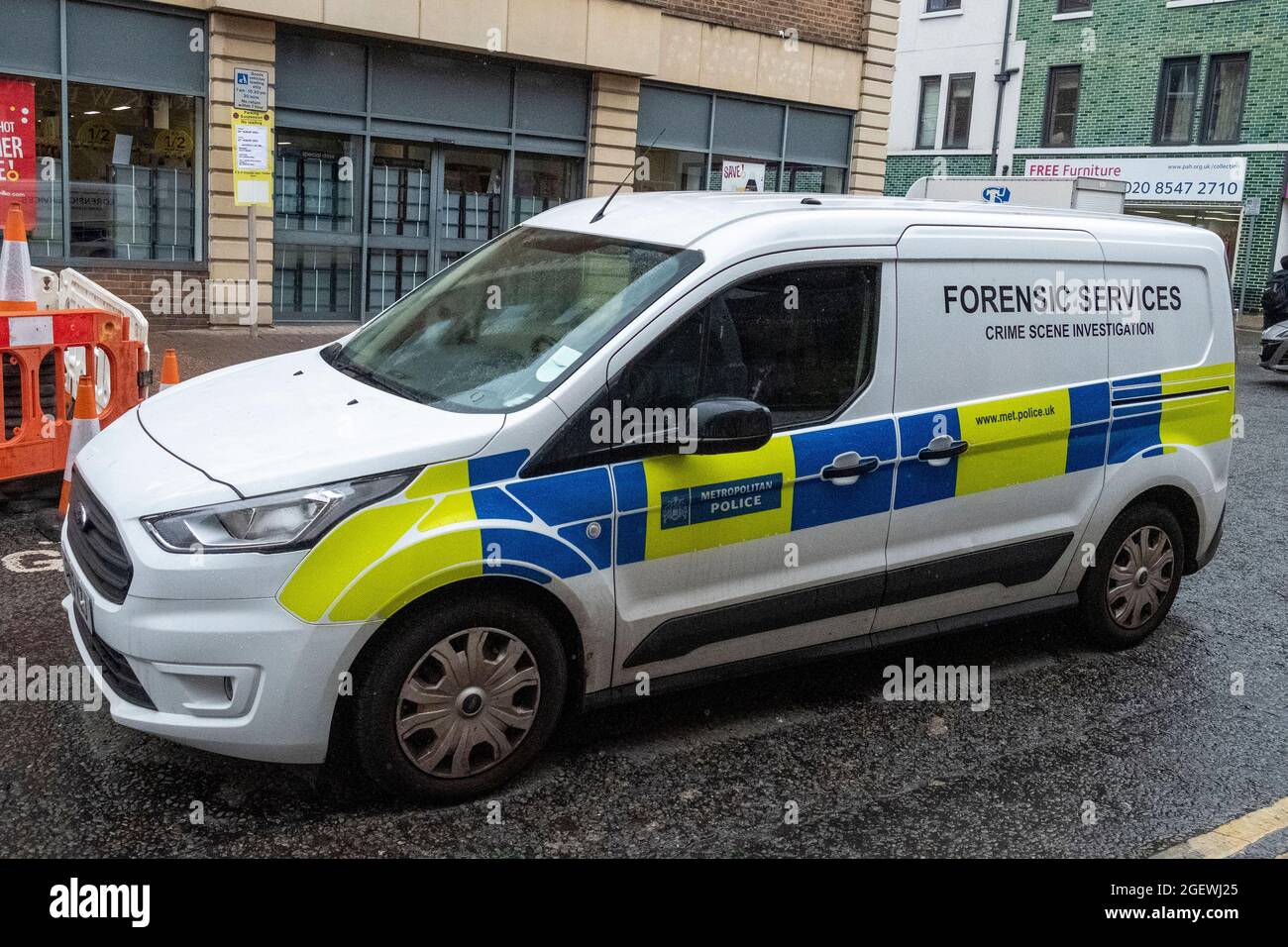 A forensic scene vehicle is parked as police officers investigate a ...
