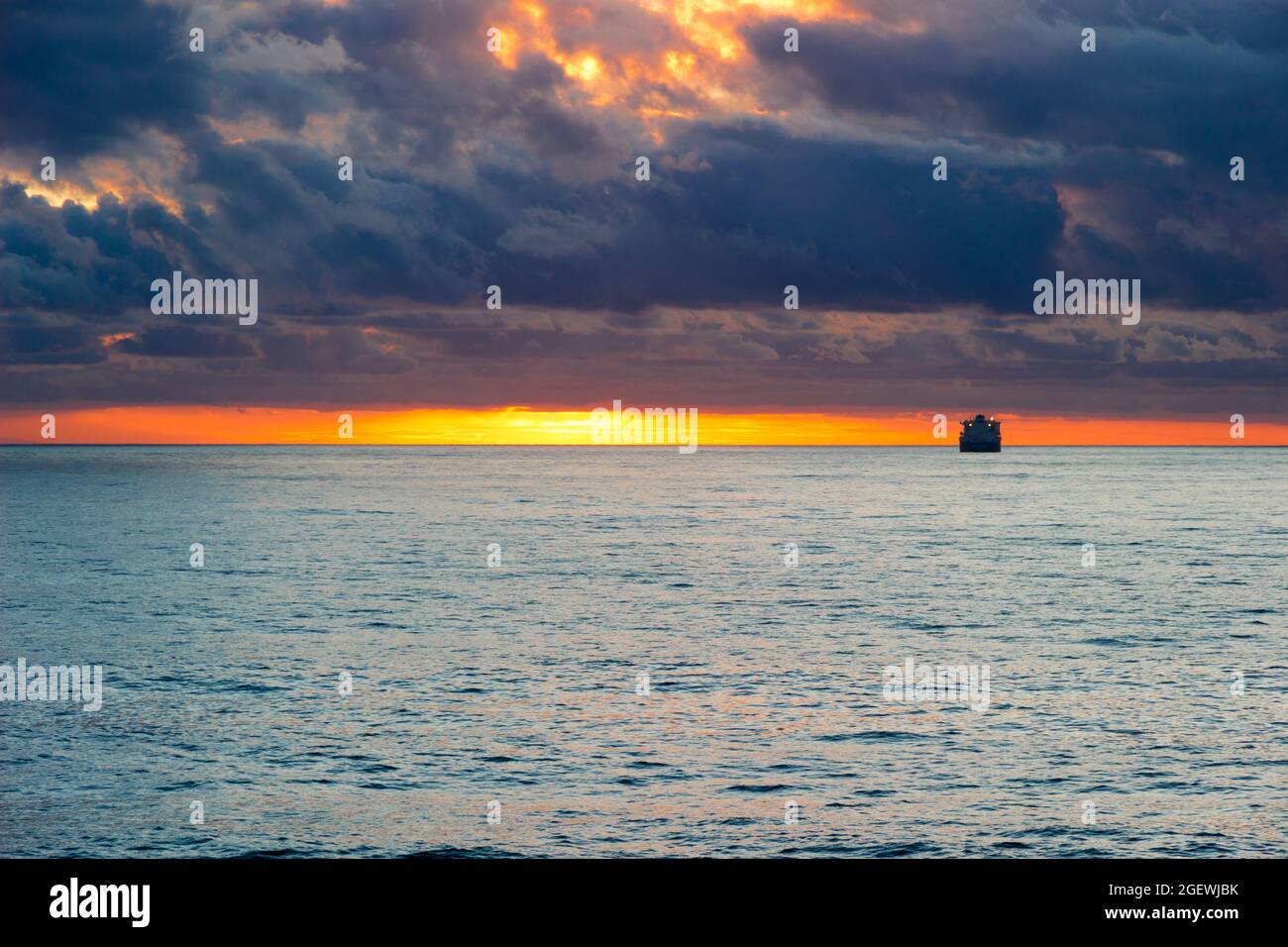 Sea sunset landscape with cloud sun reflection and ship on the horizon ...