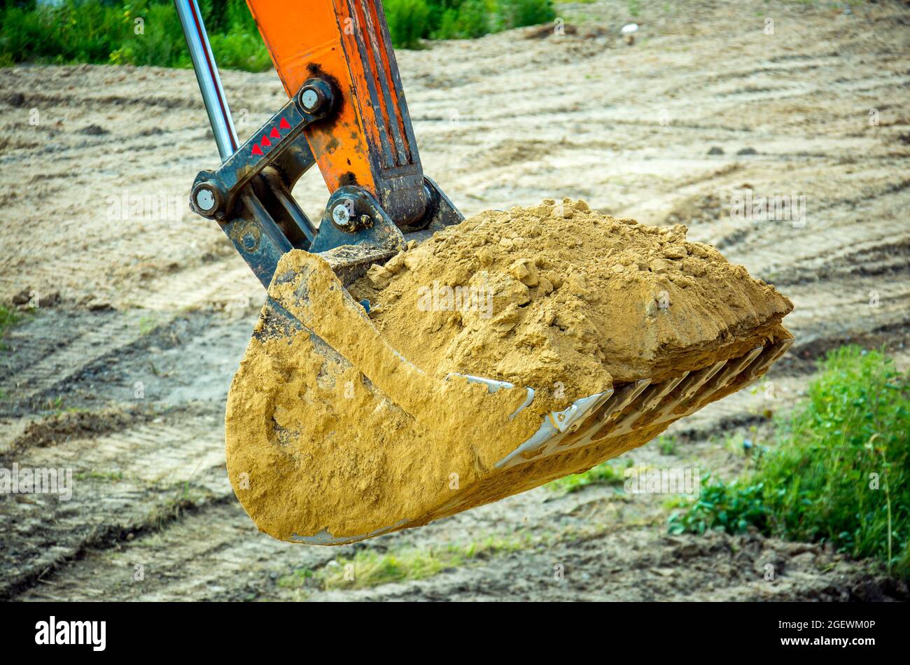 Closeup bucket of backhoe digging the soil at construction site ...