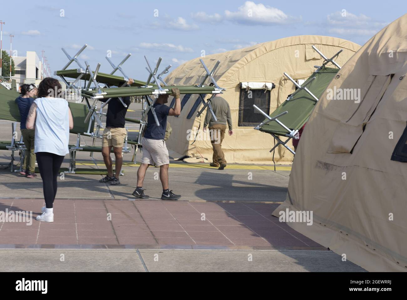 Civilian, military spouse and USO volunteers transport cots at Ramstein ...