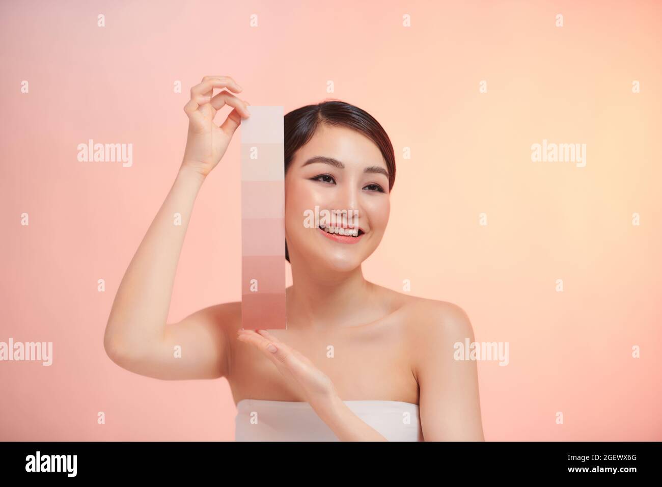 woman take skin color scale on the beige background Stock Photo - Alamy